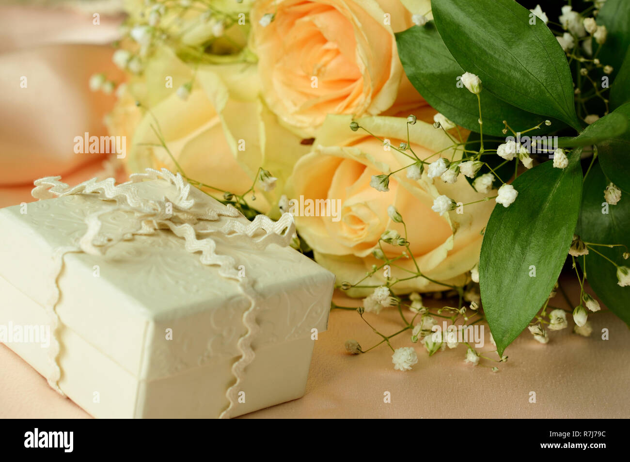 Small gift and roses on peach background Stock Photo - Alamy