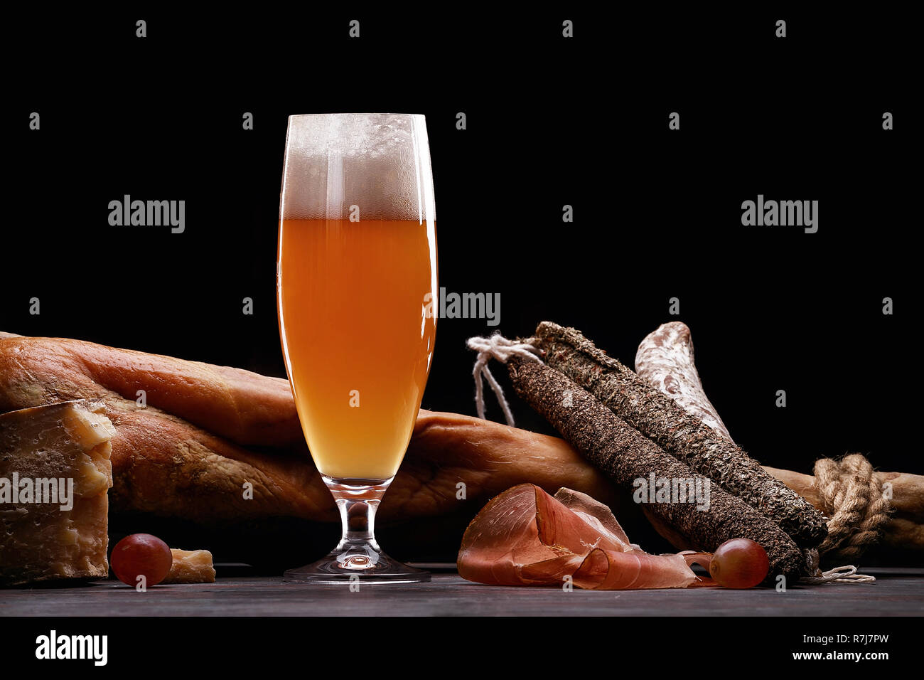 A glass of light beer foam, leg, Parma ham, expensive varieties of ...