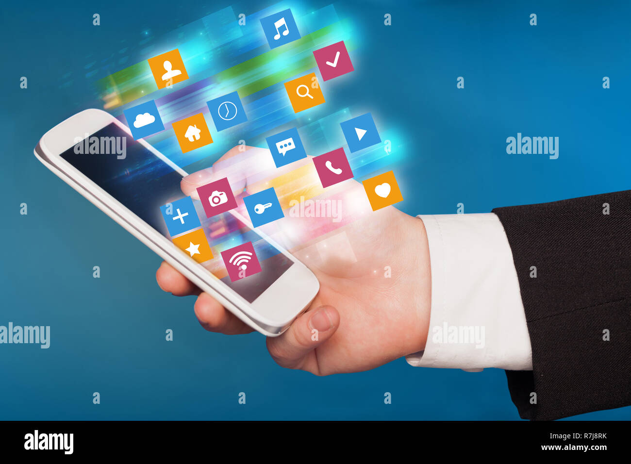 Hand using phone with colorful fast moving application icons and ...
