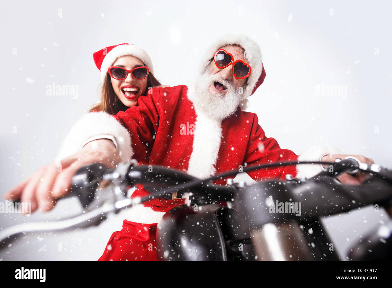 Santa Claus with white beard wearing sungasses and young mrs. Claus ...