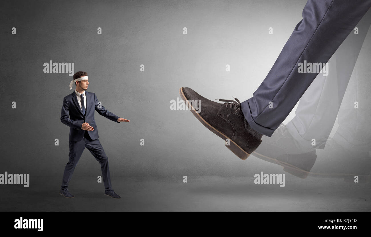Big foot treading small young karate man Stock Photo - Alamy