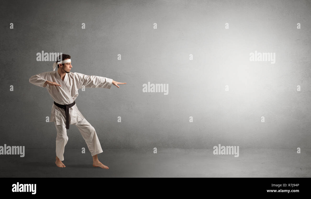 Small karate man fighting in an empty grey copy space Stock Photo - Alamy
