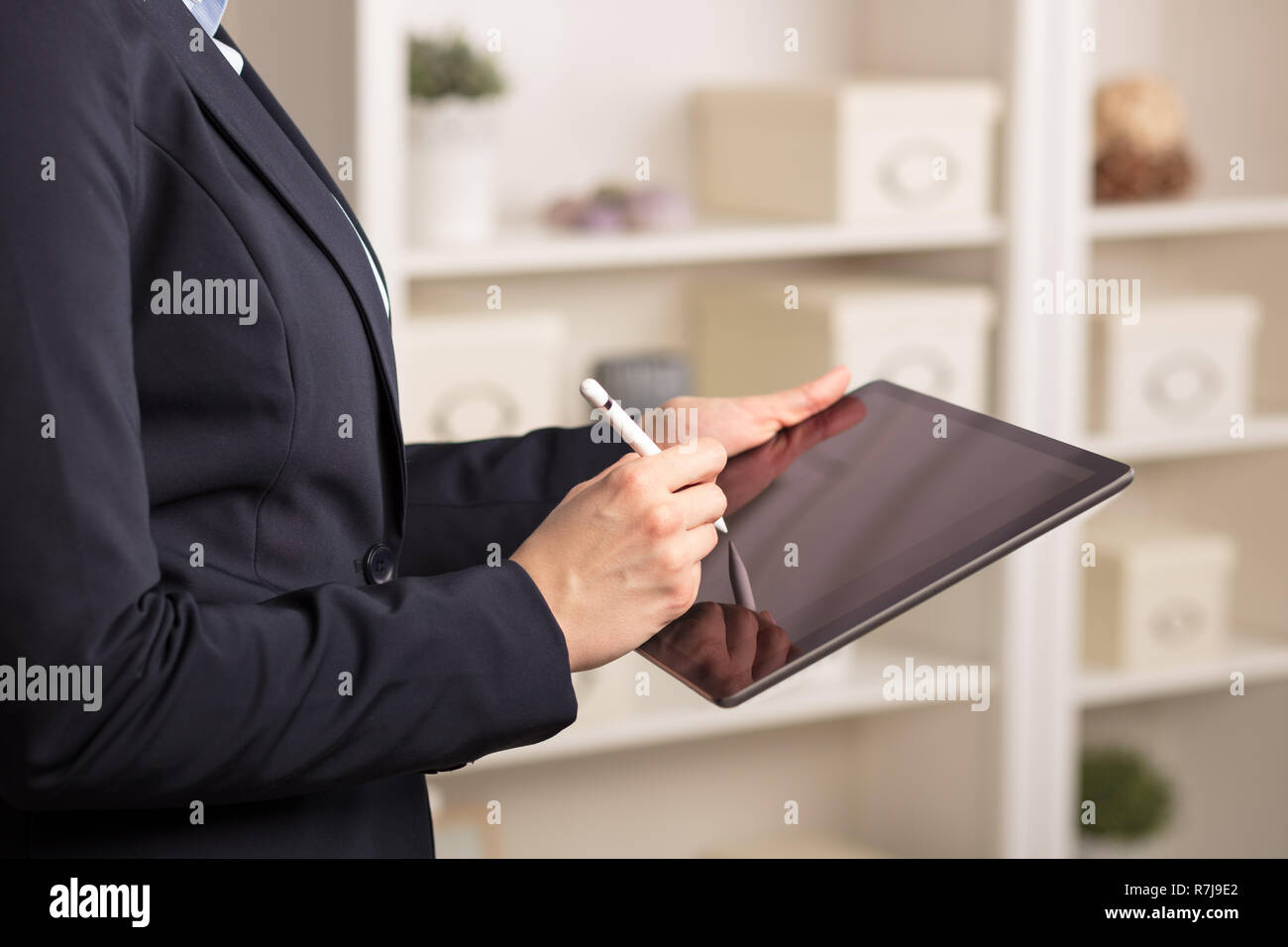Business woman below chest using tablet in a homey environment Stock ...