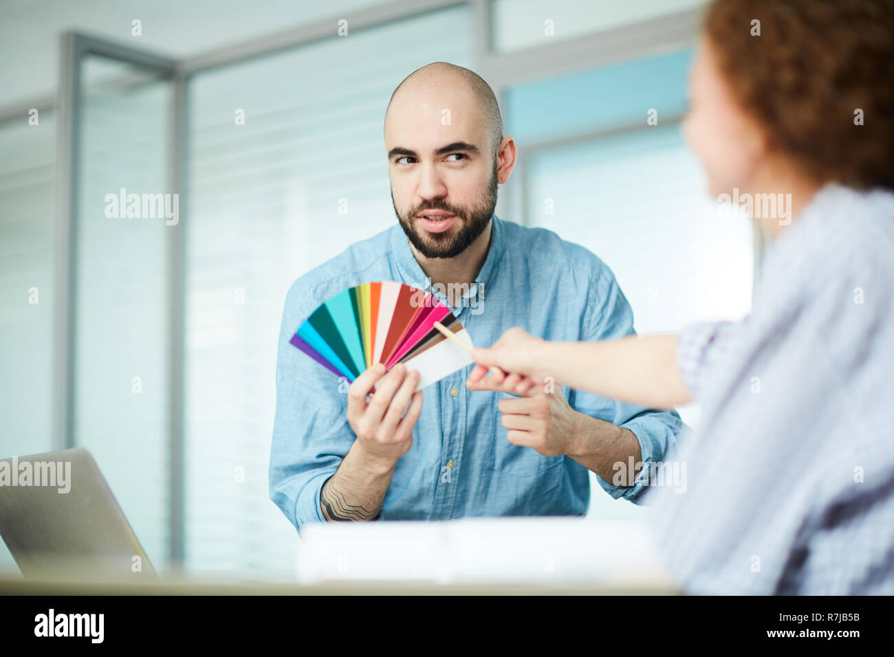 Bearded designer asking advice of colleague about color combinat Stock ...