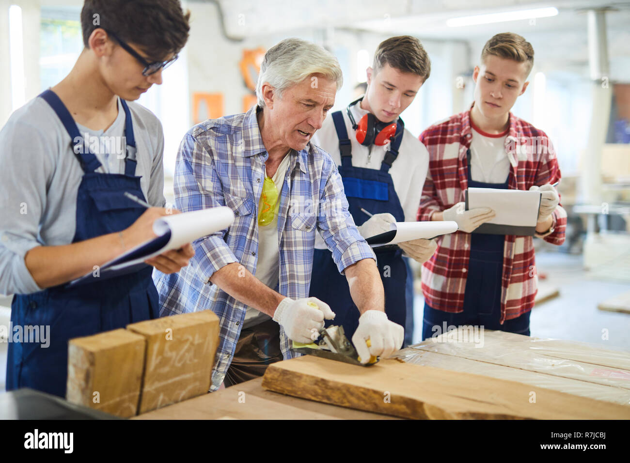 Professional carpenter explaining how to make wooden plank smoot Stock ...