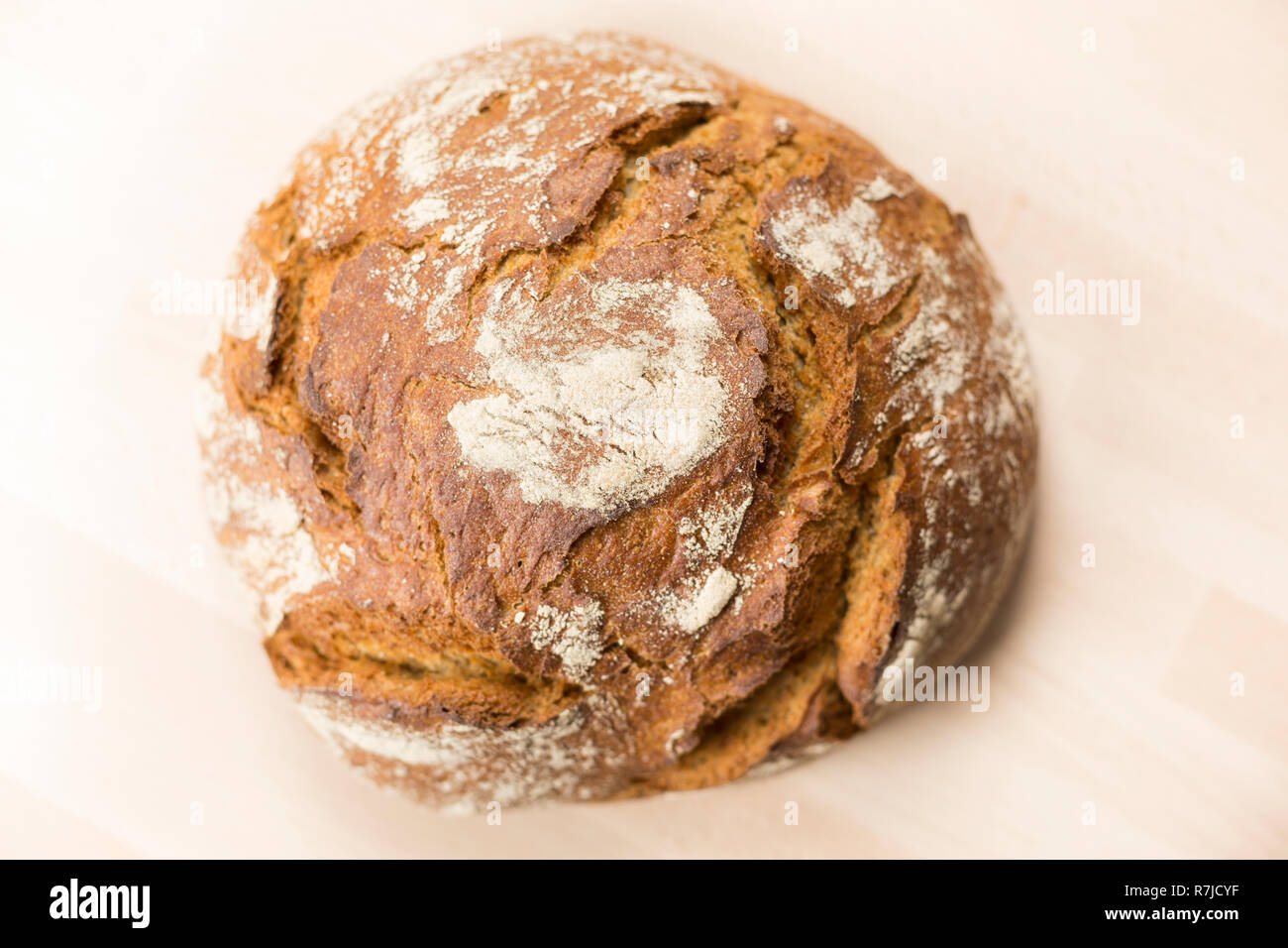 A typical German loaf of bread lying on a wooden beech table. Closeup ...