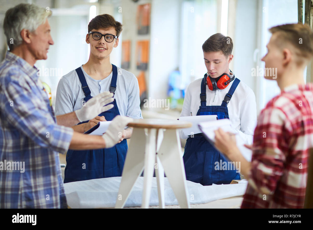 Carpenter explaining students how to make stool Stock Photo - Alamy