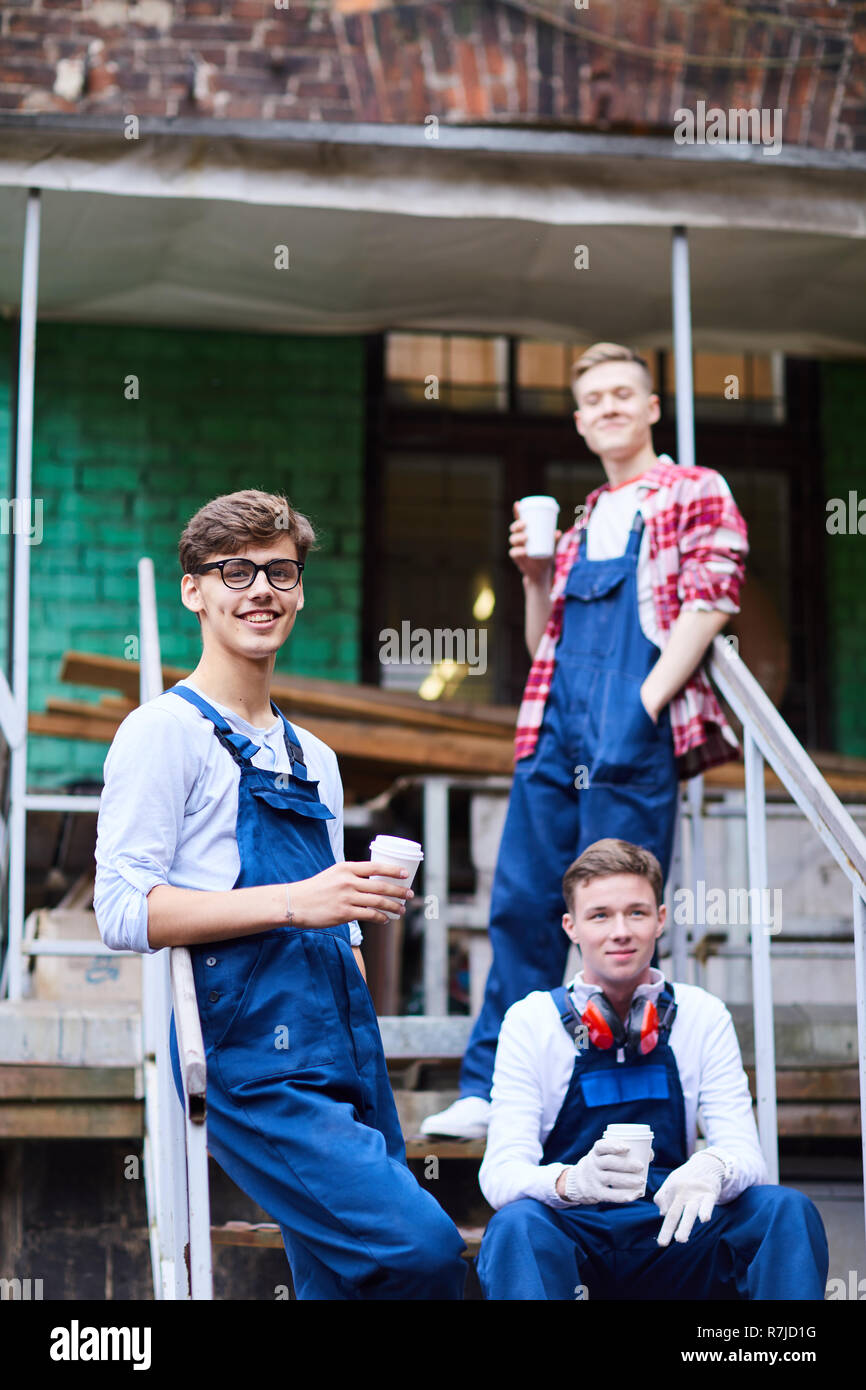 Jolly young factory workers resting on porch Stock Photo - Alamy