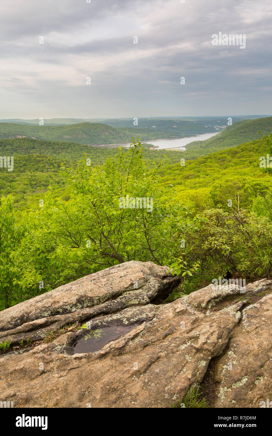 The Hudson River winding through the Hudson Highlands beyond a rocky overlook along the ...