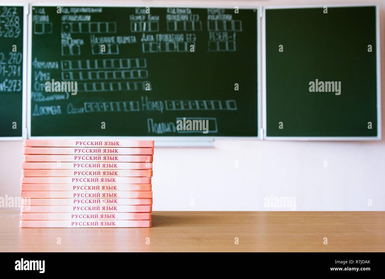 Textbooks with the inscription "Russian language" against blackboard ...