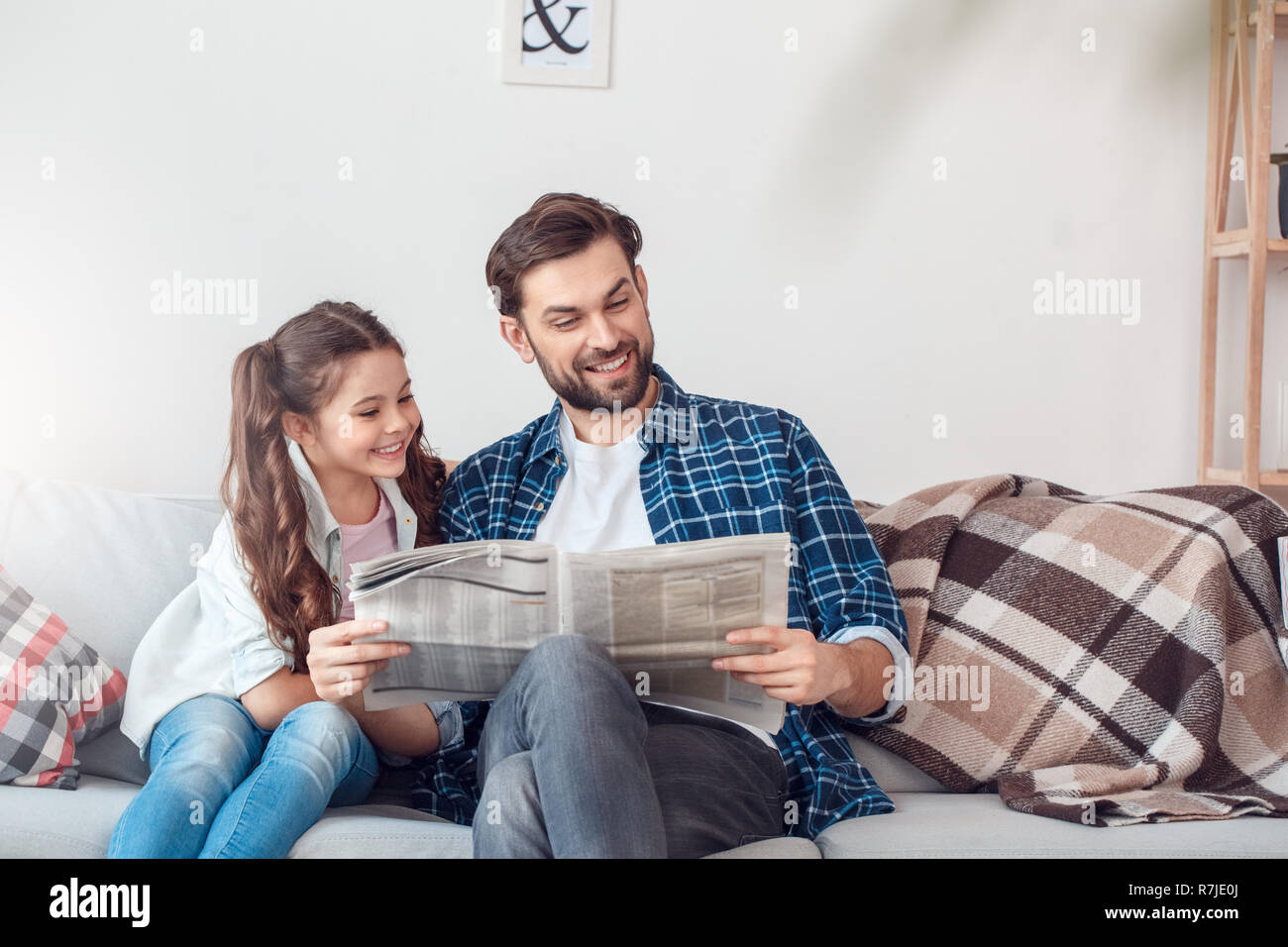 Father and little daughter at home sitting man reading newspaper girl ...