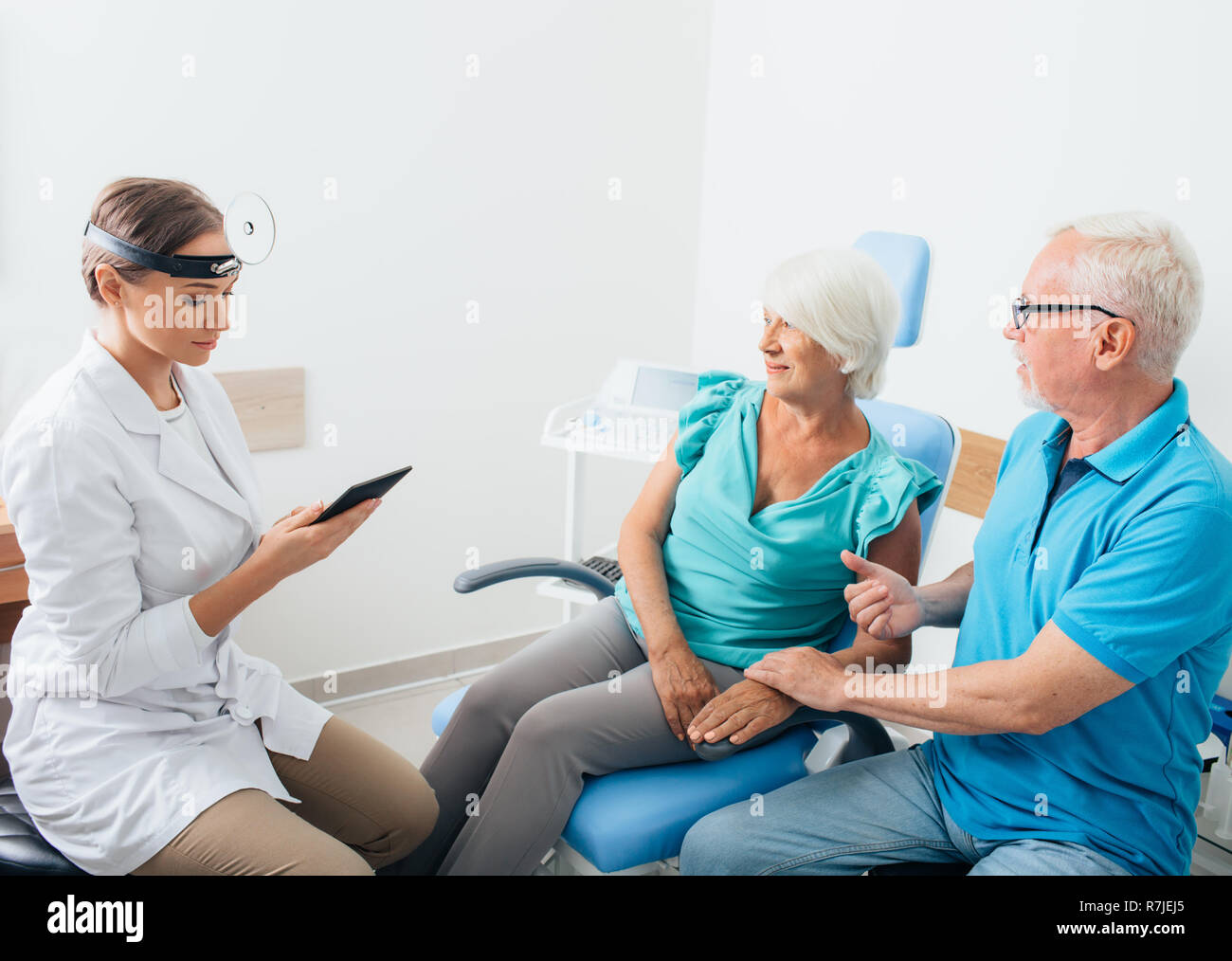 ENT Doctor talking with senior patients in doctors office Stock Photo ...