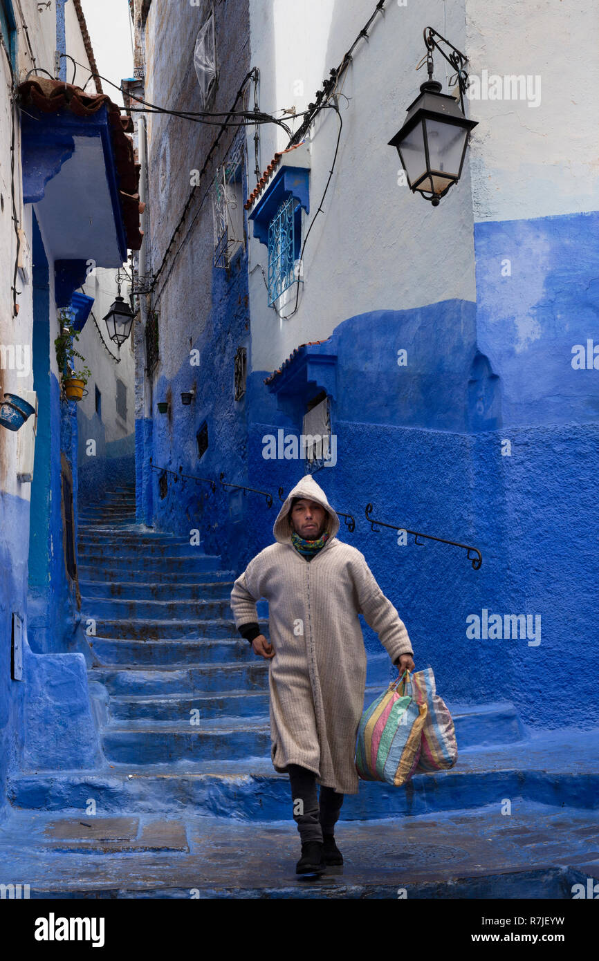 Morocco, Chefchaouen, Medina, Arab man wearing Djellaba walking down ...