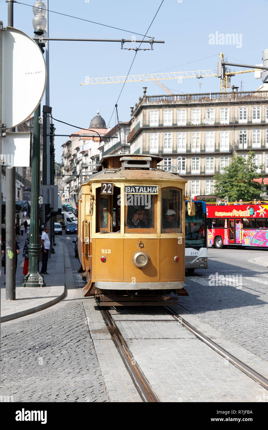 Old yellow Porto tramway in the middle of the city and traffic on the ...