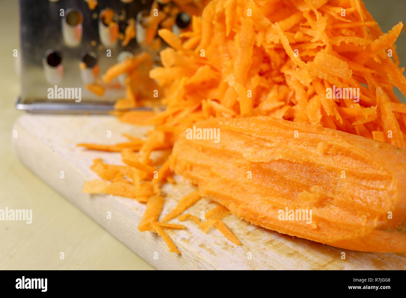 Fresh carrot grated on a metal kitchen grate. Vegetables prepared for ...