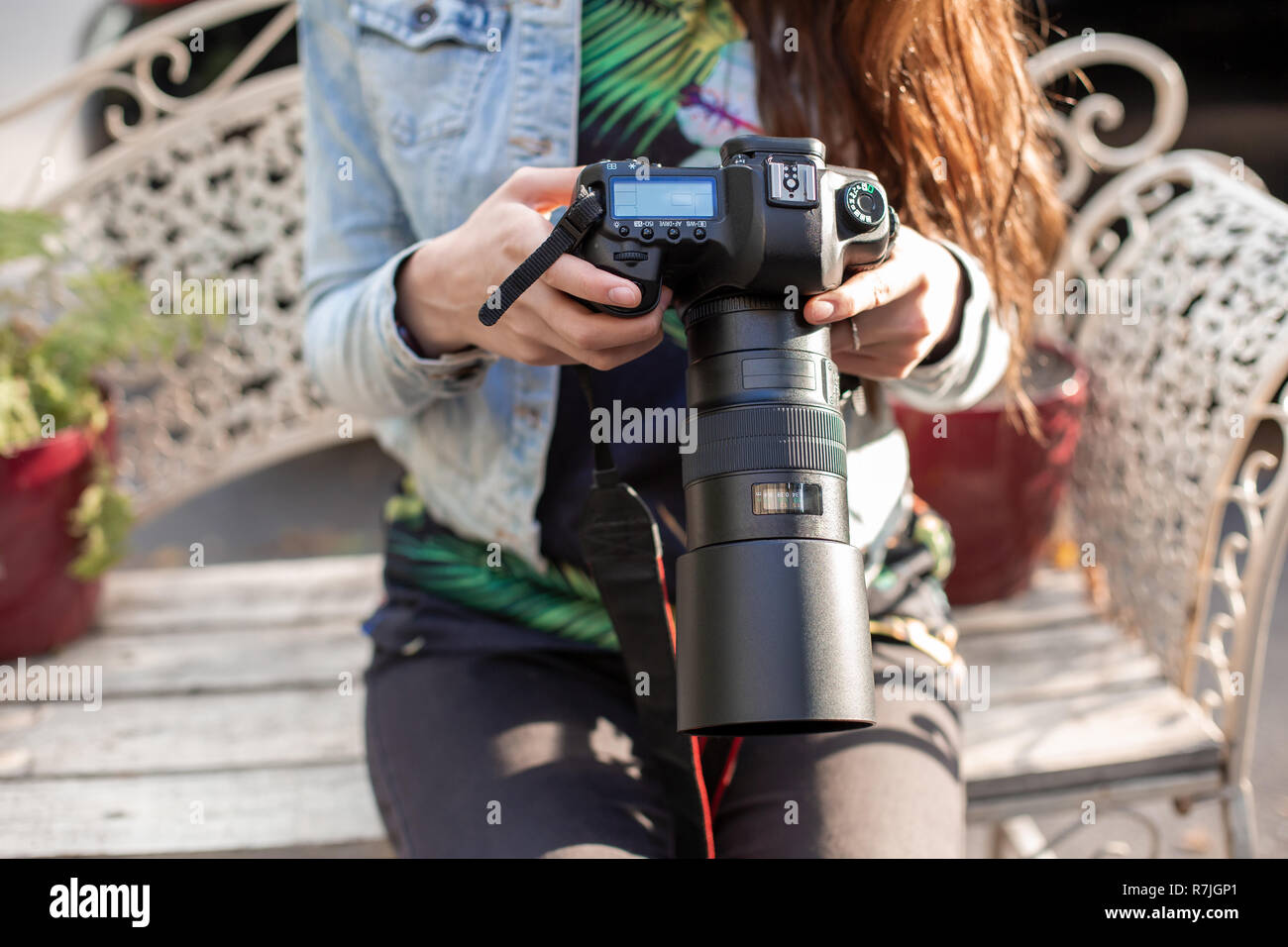 Close-up of female hands holding a professional camera. Female ...