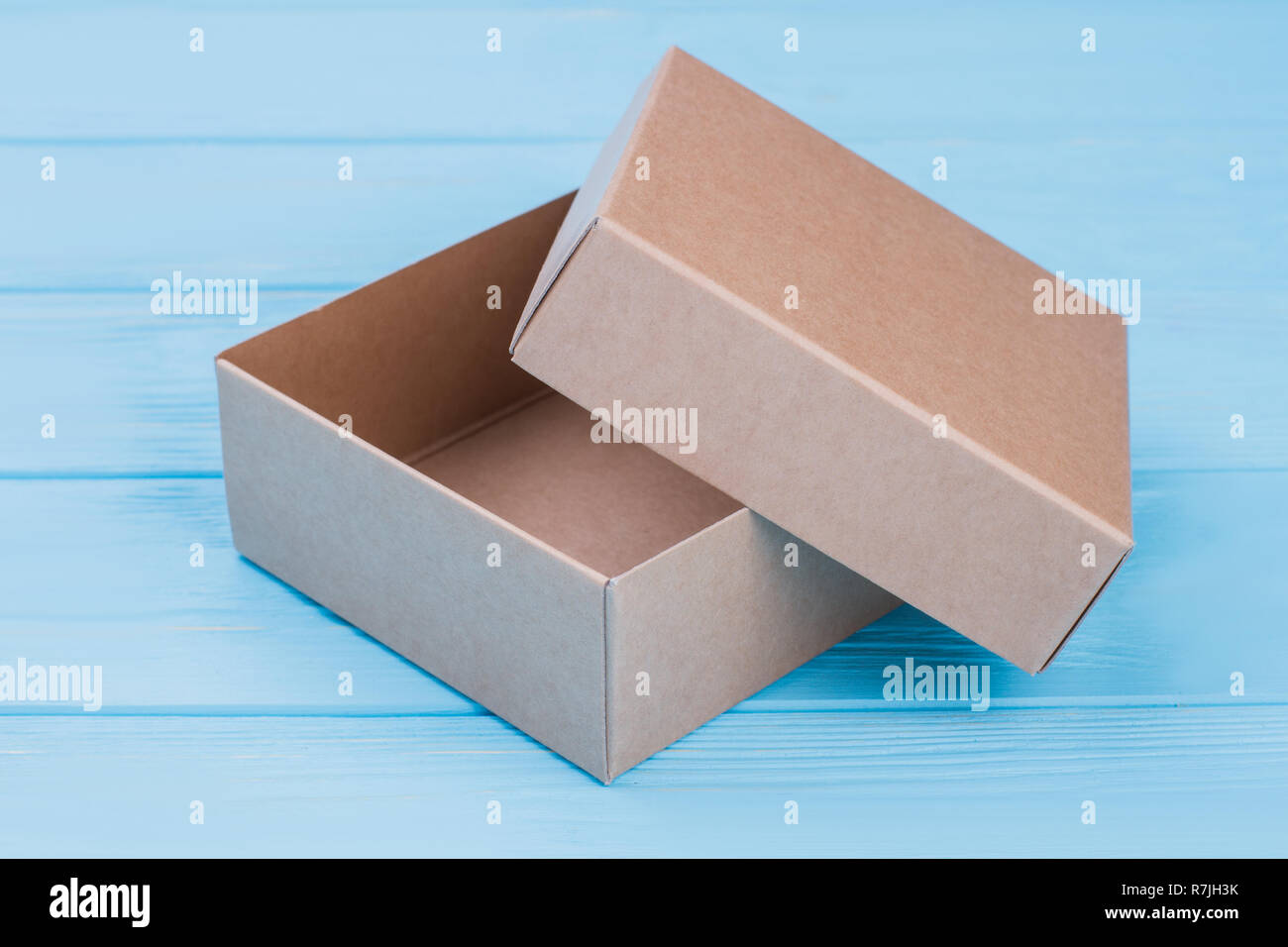 Brown craft paper box or carton. Close up. Blue wood background Stock ...