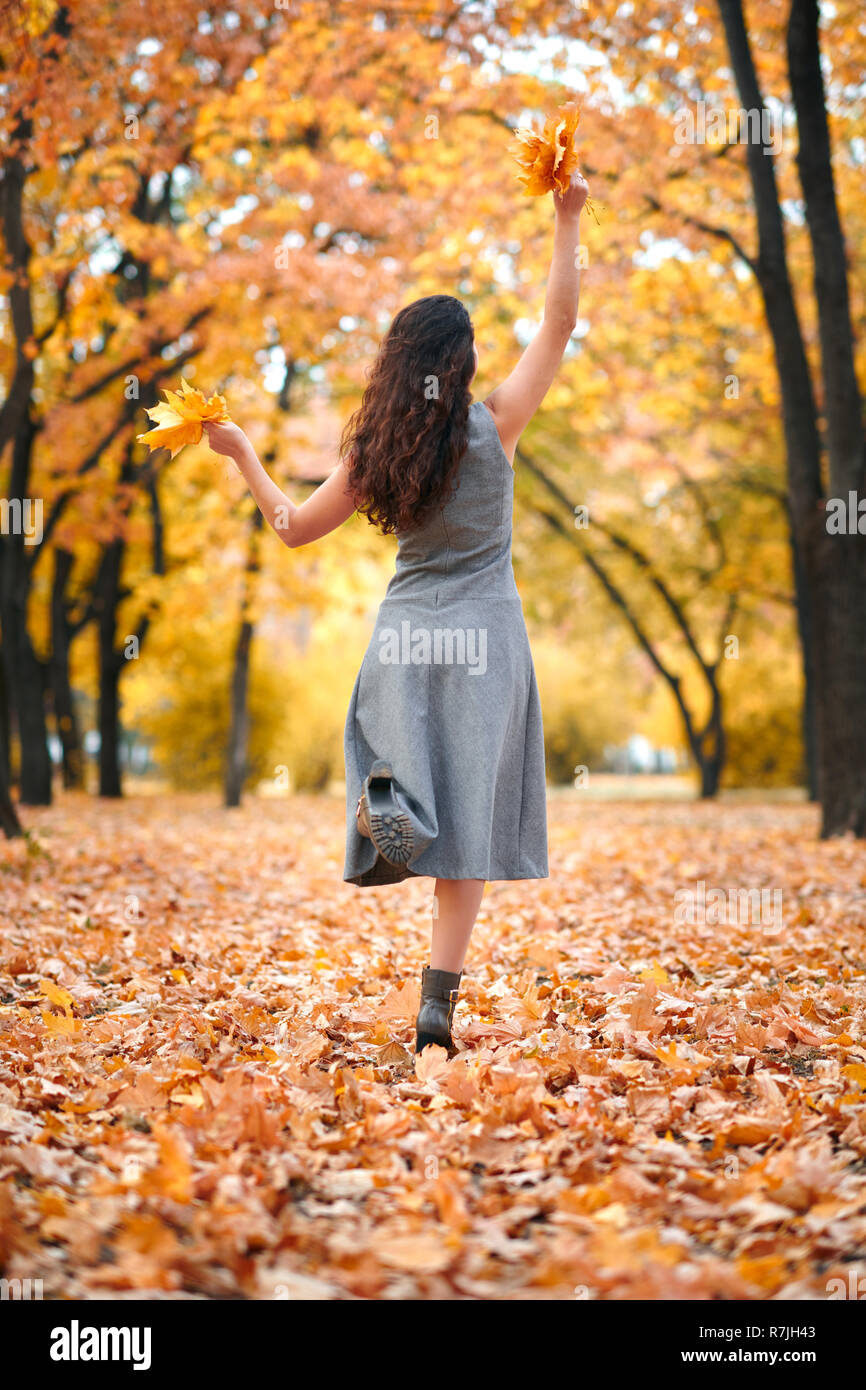 Pretty Woman Posing With Bunch Of Maples Leaves In Autumn Park