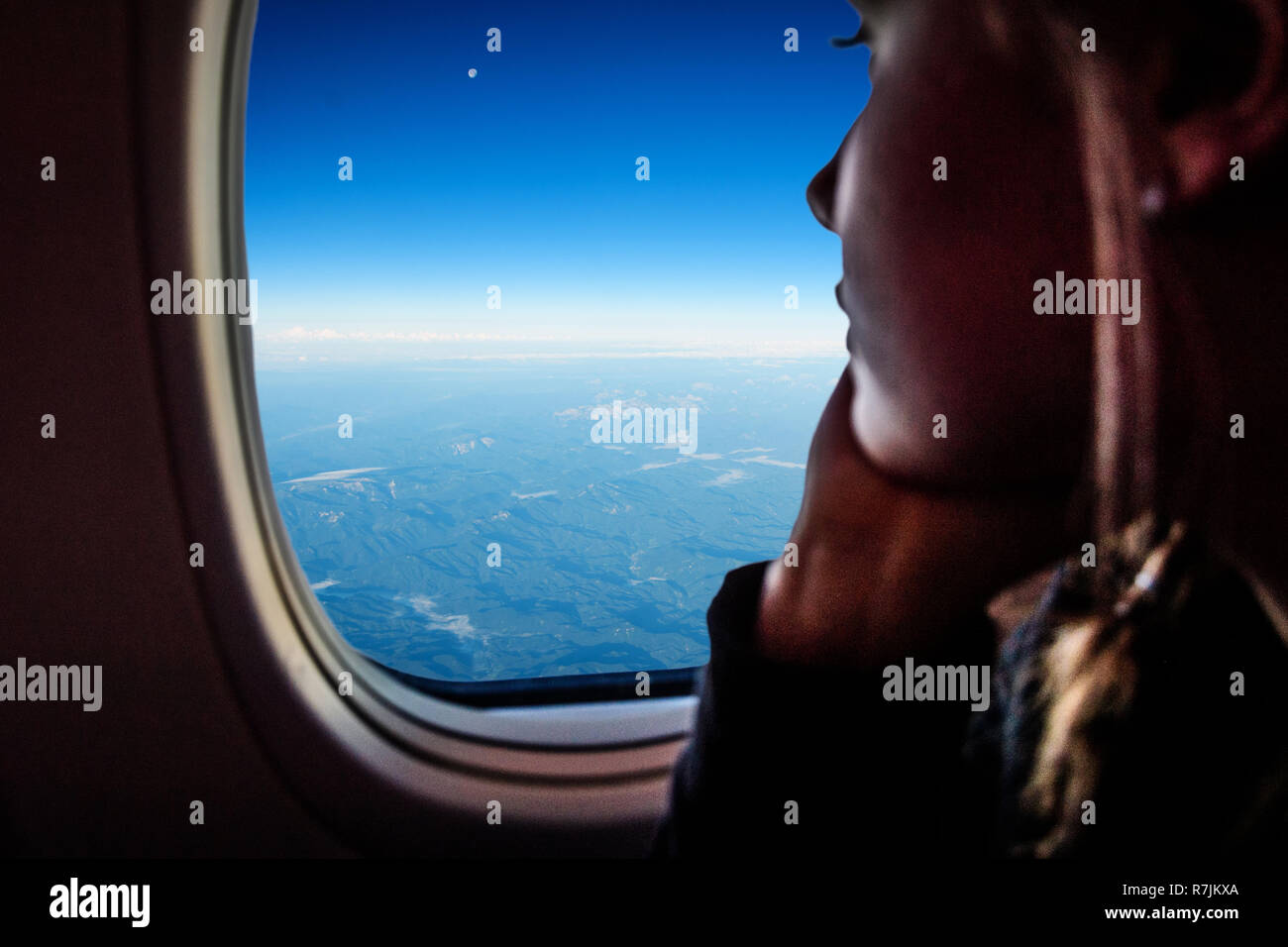 Woman looking through window of plane hi-res stock photography and ...