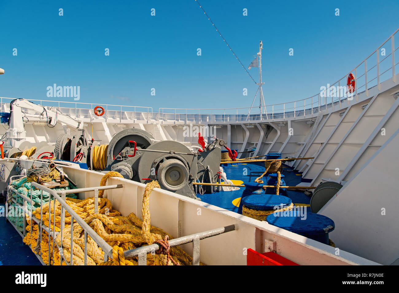Ship stern deck with nautical ropes, mooring winch, hook and lifebuoy ...