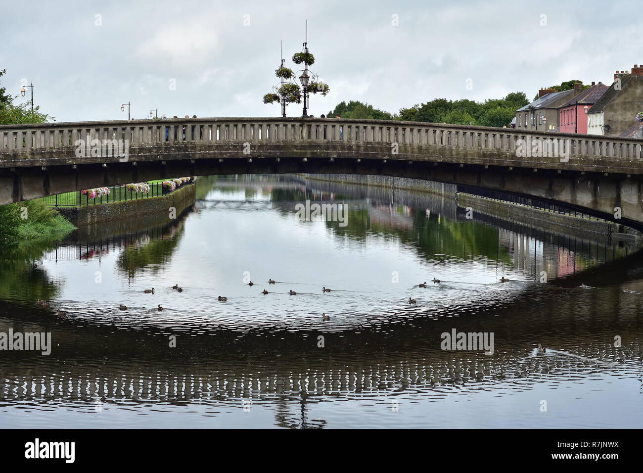 Concrete bridge over River Nore reflecting on calm water surface in ...