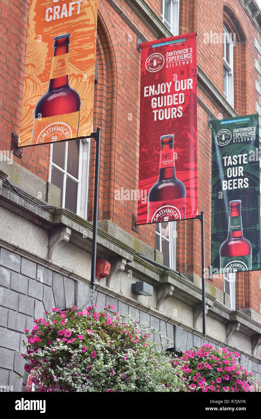 Colorful Irish ale advertisements on brick exterior wall with flower ...