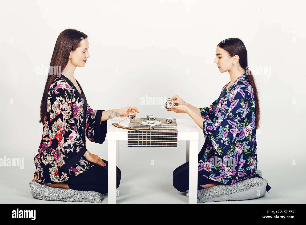 Beautiful girls drinking a tea in a studio Stock Photo - Alamy