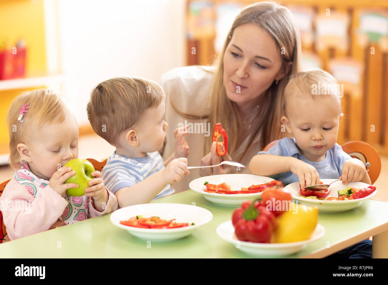 teacher and preschooler kids having break for fruits and vegetables in ...