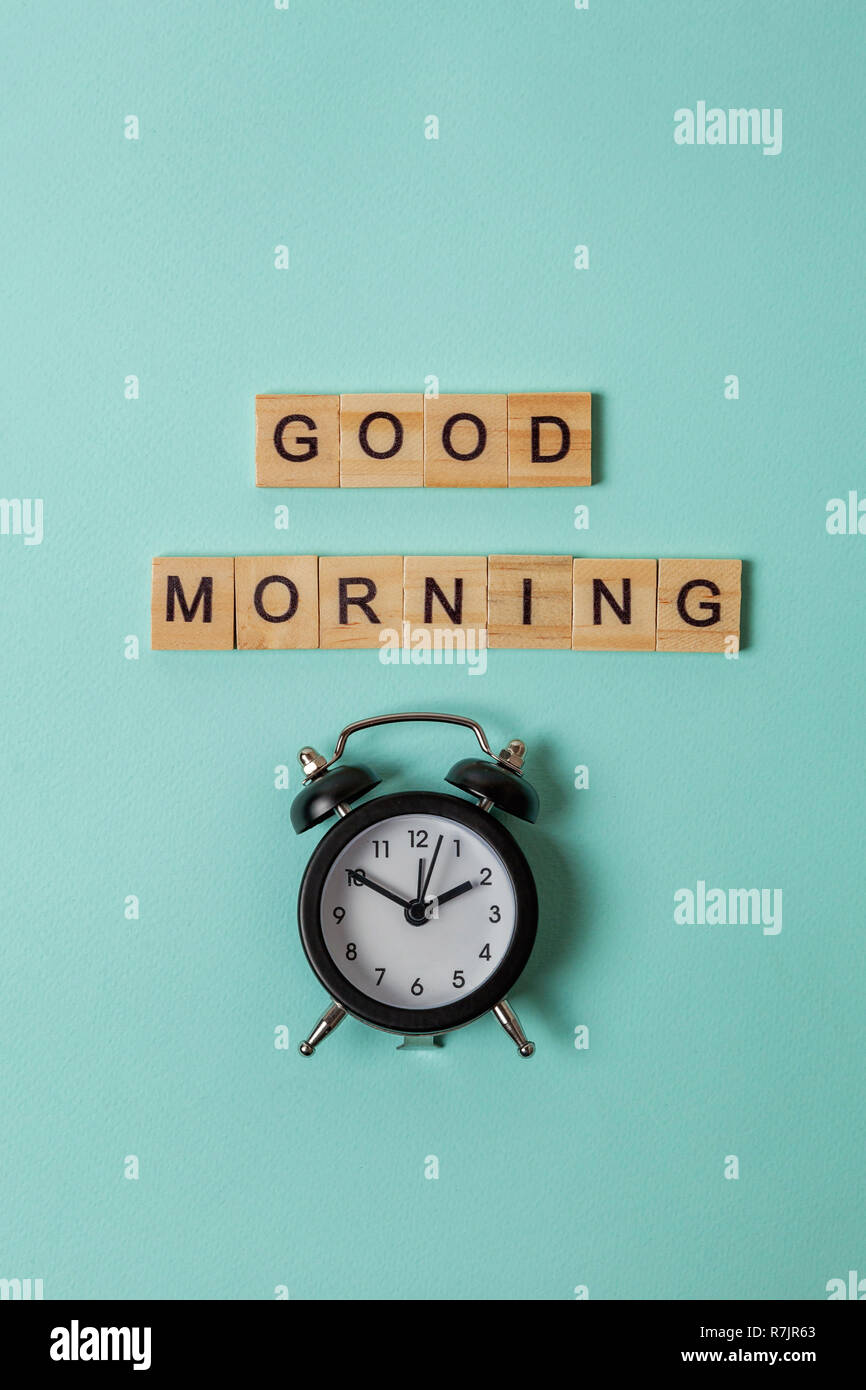 Simply flat lay design alarm clock and Inscription GOOD MORNING letters ...