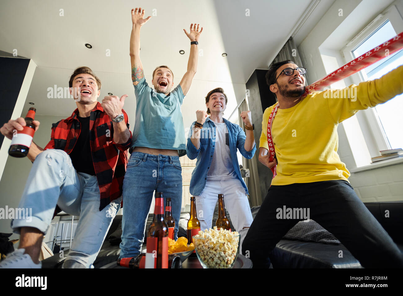 Group of happy football fans supporting their football team on TV at ...