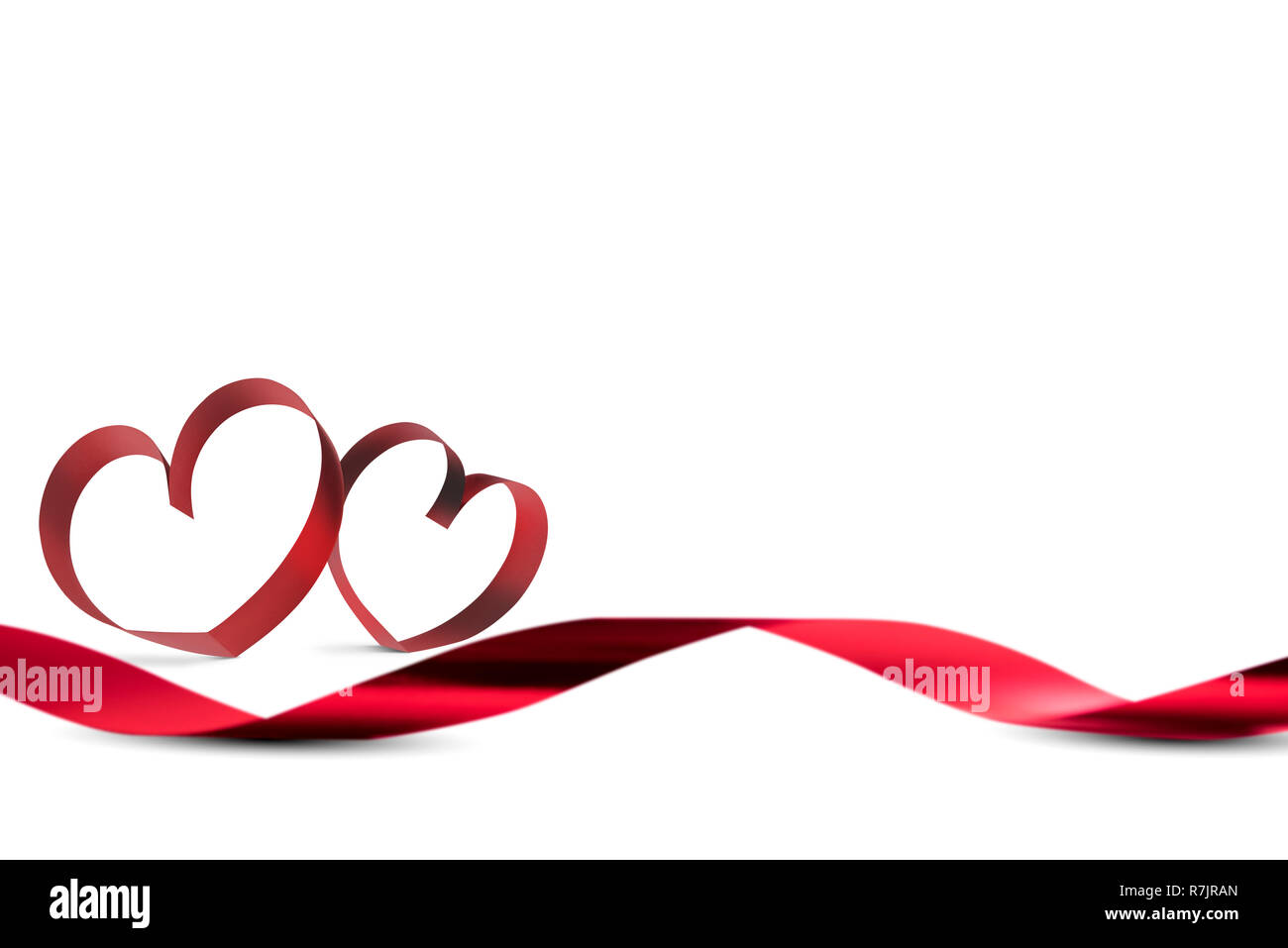 Red ribbons with ribbons shaped as hearts over white background. Love ...