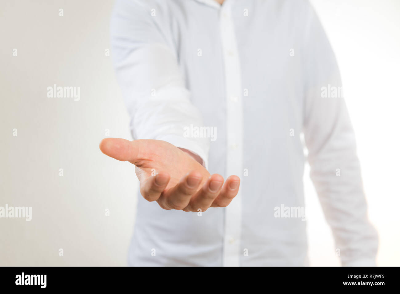 man with white shirt stretching out empty hand against white background ...