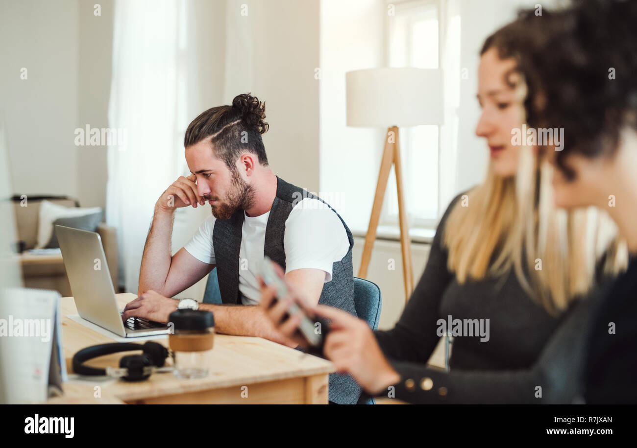 Group of young businesspeople with smartphone working together in a ...