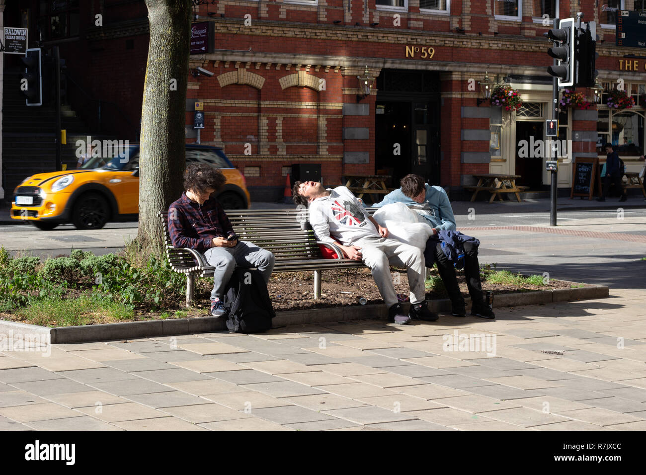 Two youths are unconscious on a park bench in a city centre in the ...