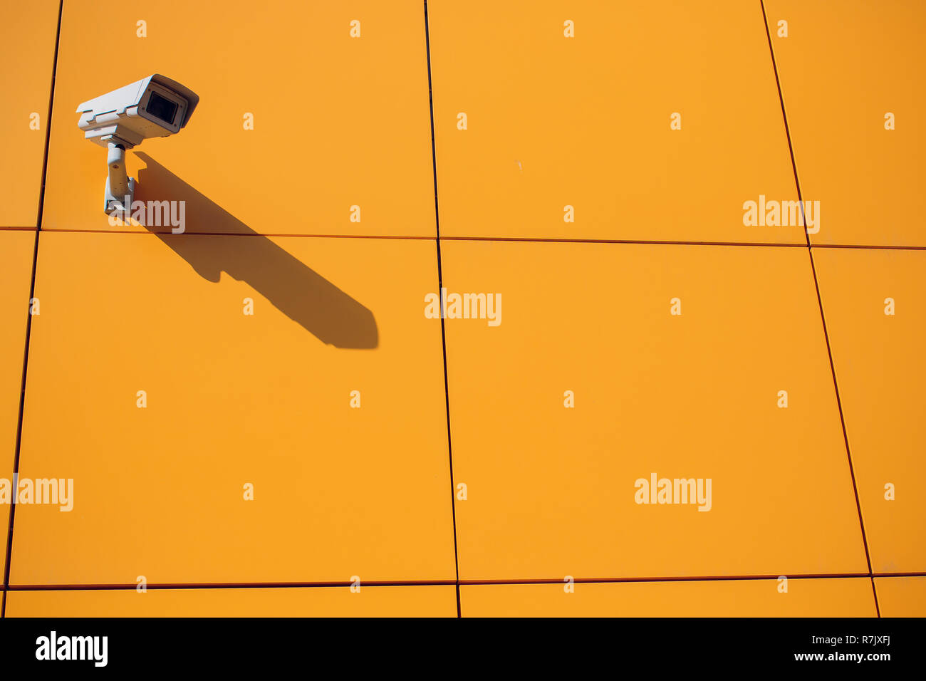 Modern CCTV camera on wall. A blurred night cityscape background ...