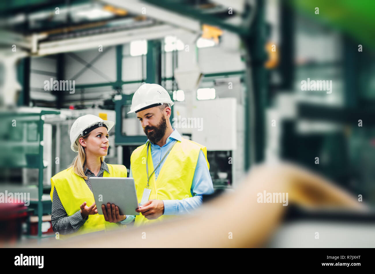 A portrait of an industrial man and woman engineer with tablet in a ...