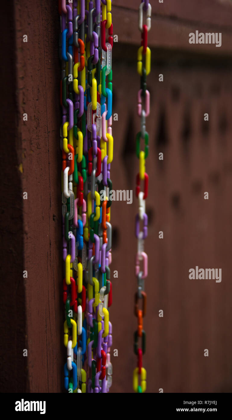 Decorative colored chains on an old wooden wall Stock Photo - Alamy