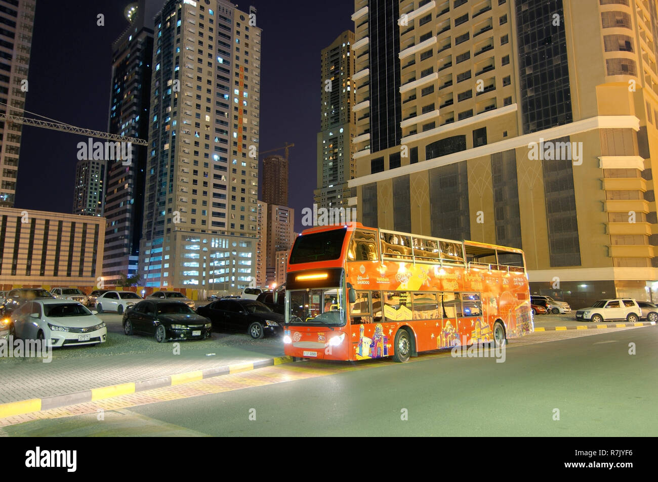 Red double decker tour bus, at night, Sharjah, Emirate of Sharjah ...