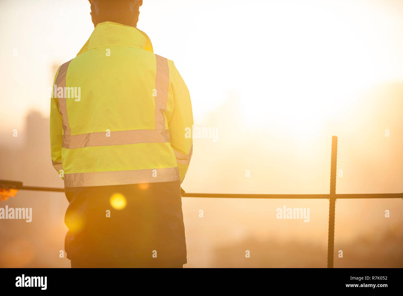 Worker at the construction site and sunrise background Stock Photo - Alamy