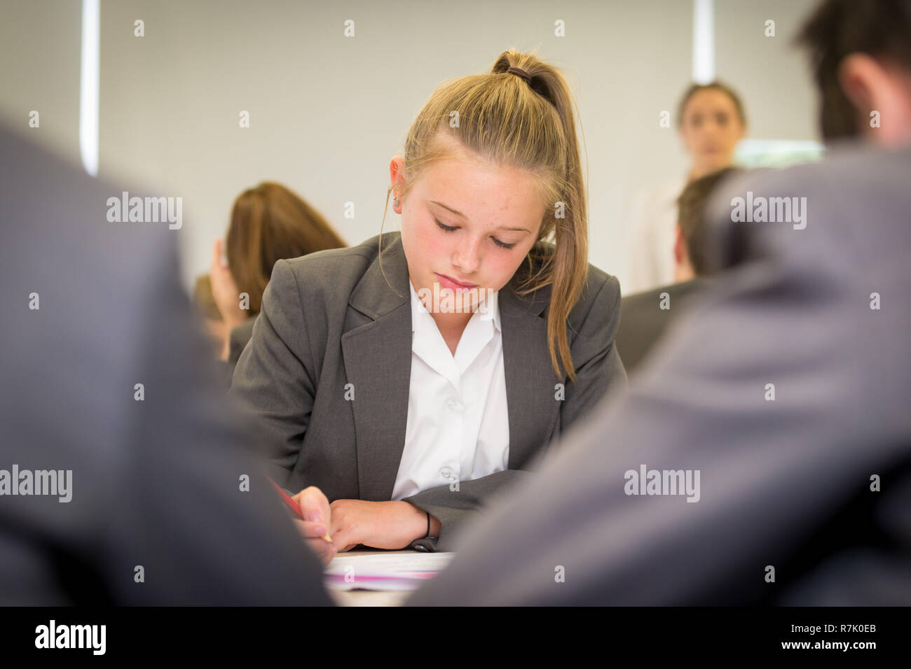 14 year old white school girl in a classroom with other pupils, UK 2018 ...