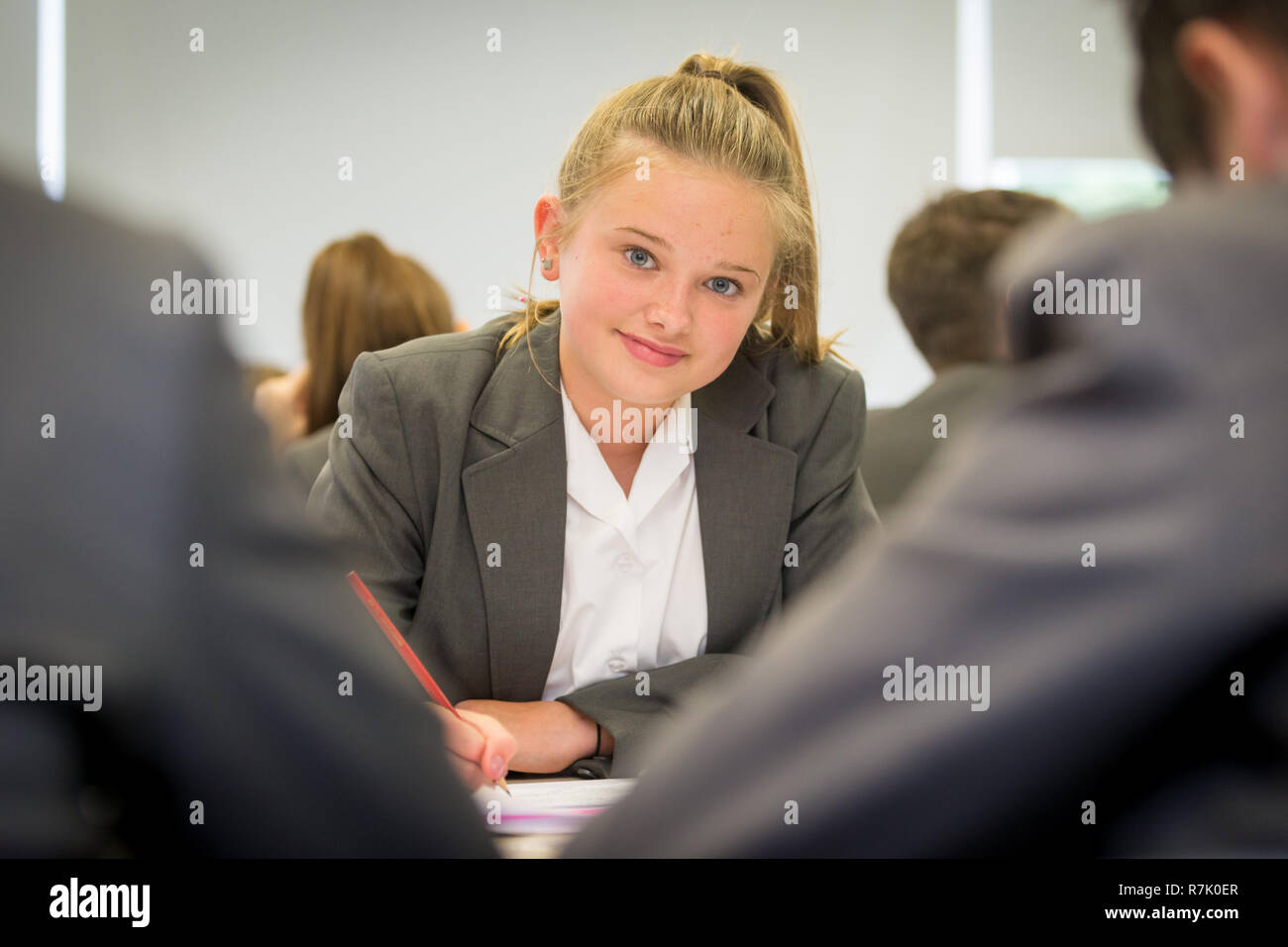 14 year old white school girl in a classroom with other pupils, UK 2018 ...