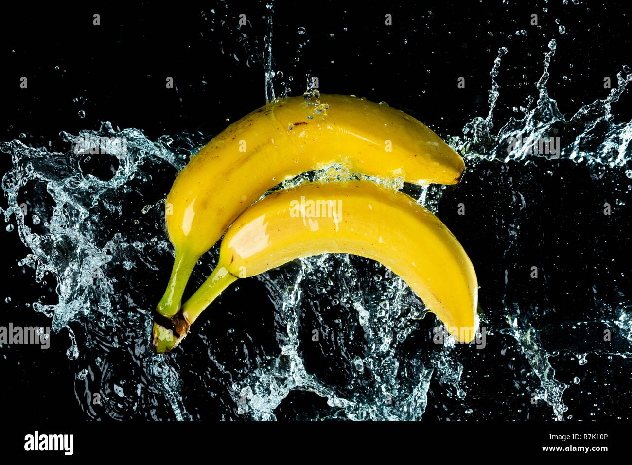Bananas Water Splash on white background Stock Photo - Alamy