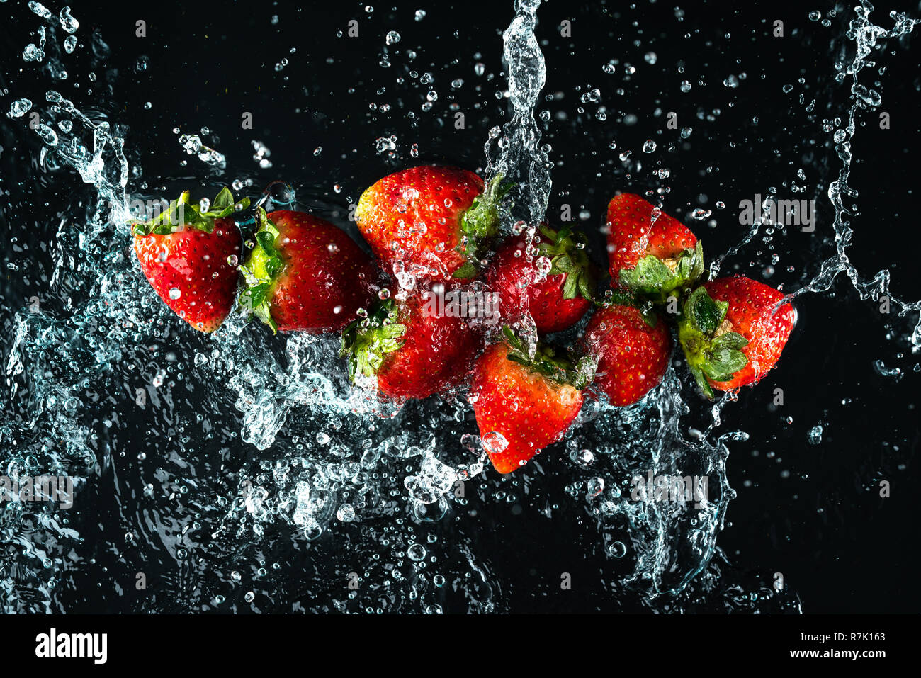 Strawberries Water Splash on black background Stock Photo - Alamy