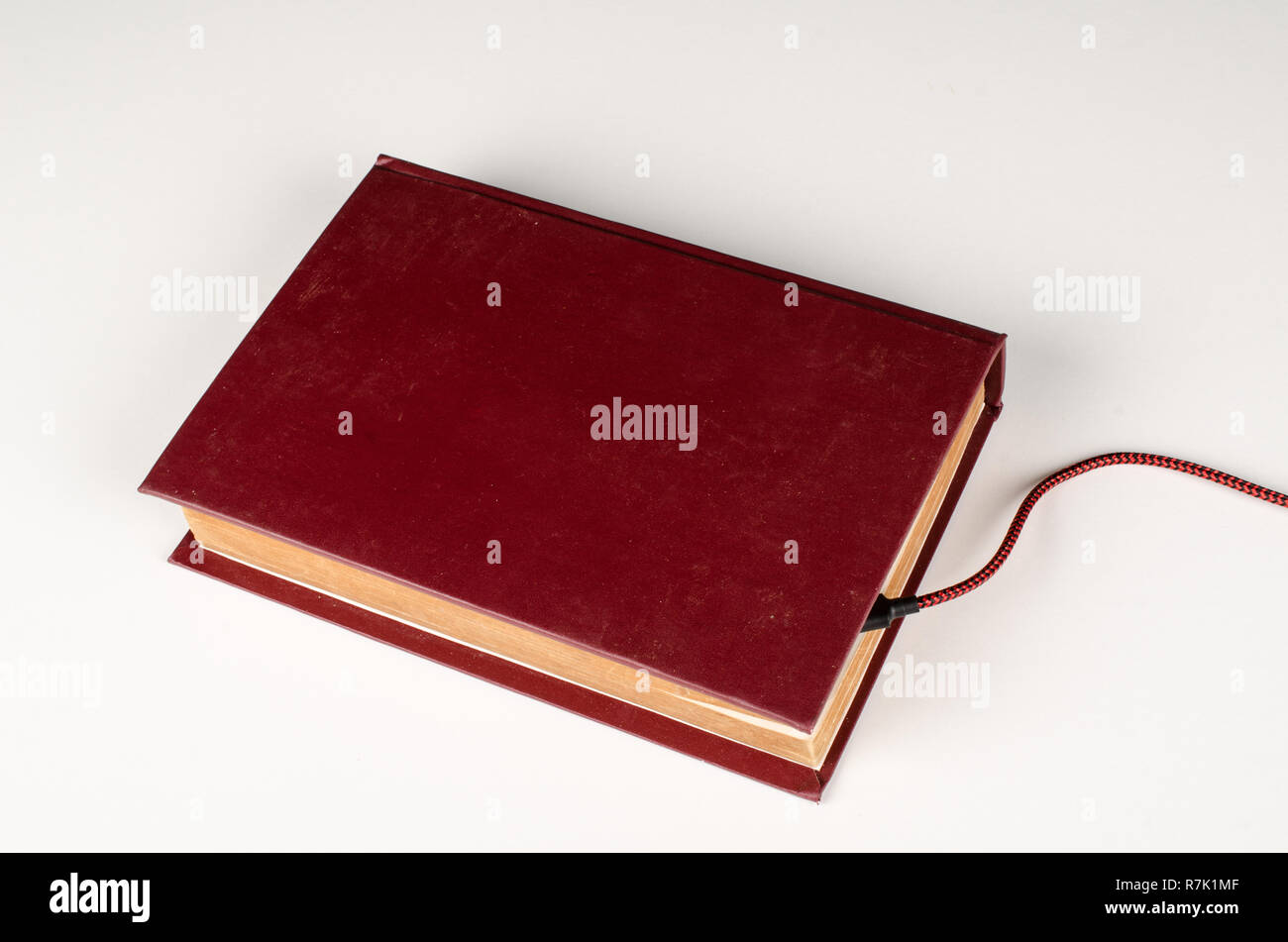 Old book with a battery charging cable, a concept of analog versus ...