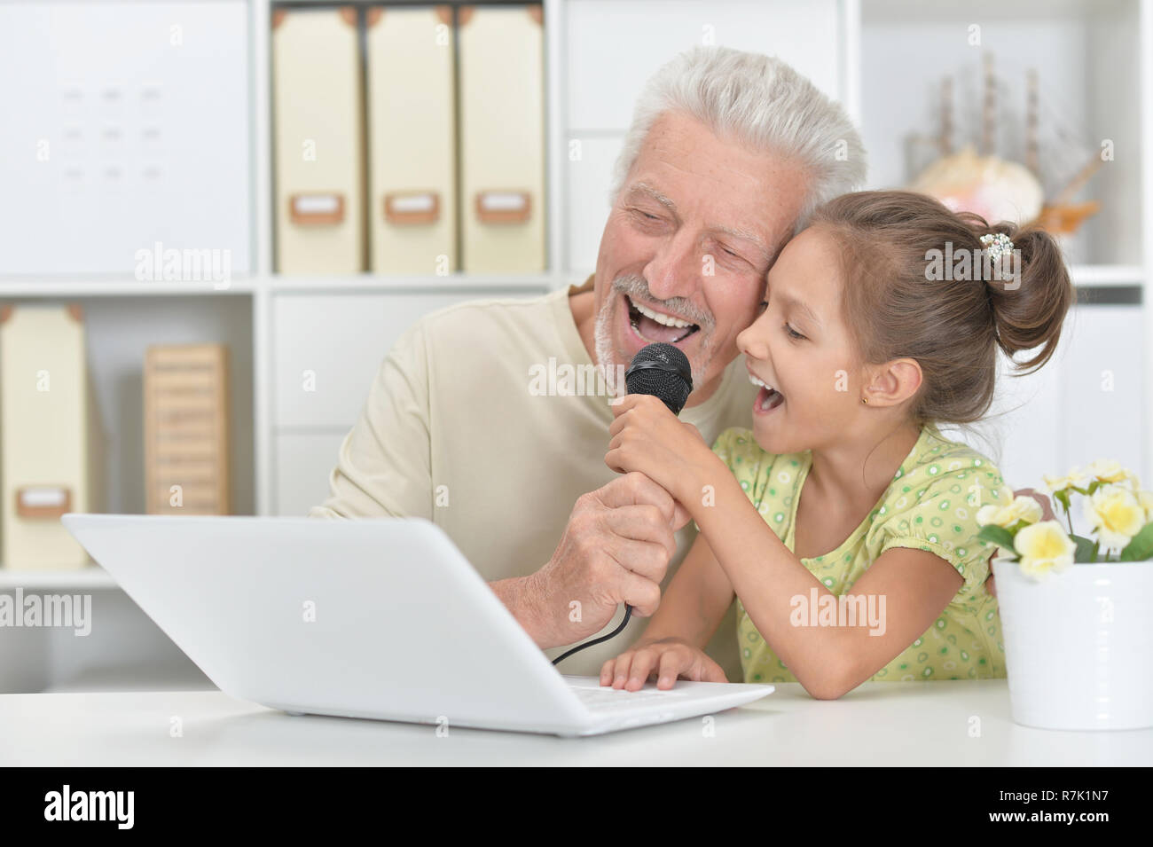 Portrait of grandfather and granddaughter singing karaoke Stock Photo ...
