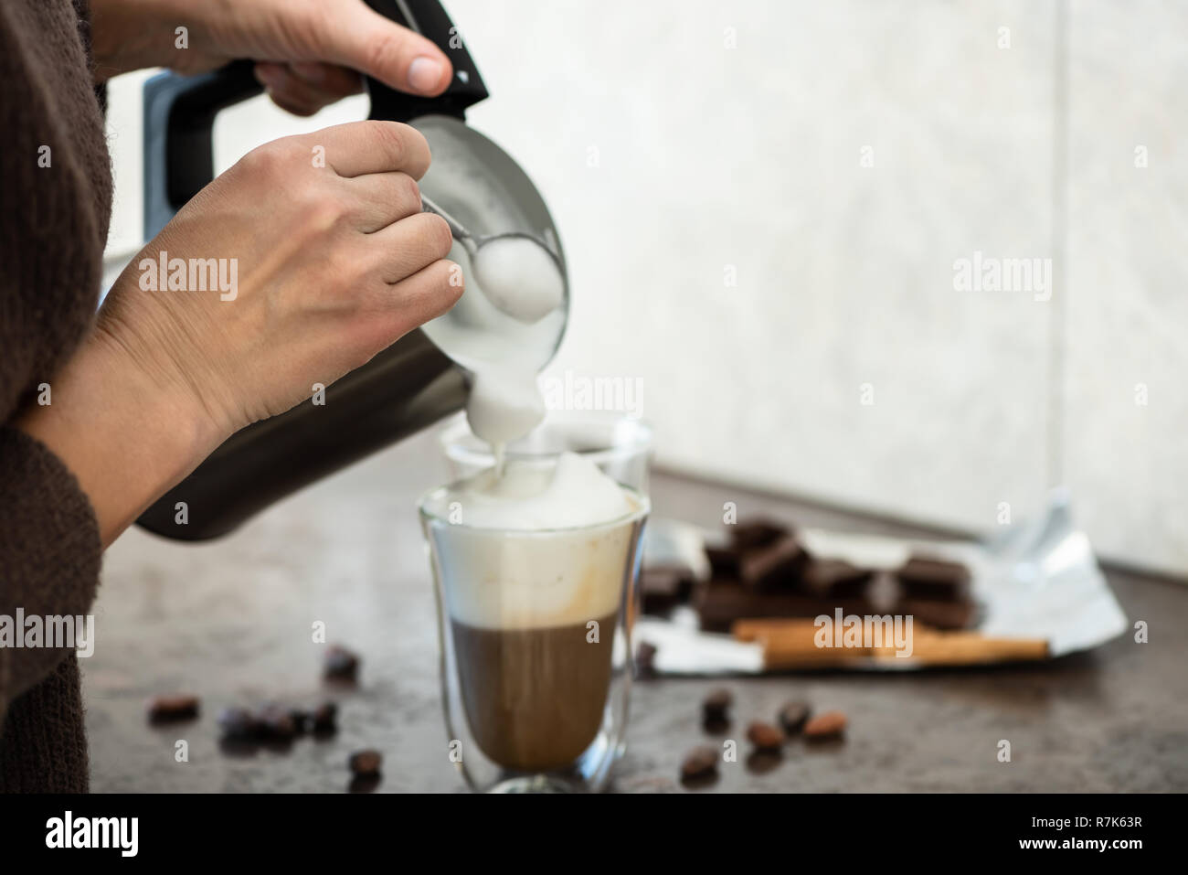 The human hand is putting milk foam in a glass of coffee Stock Photo ...
