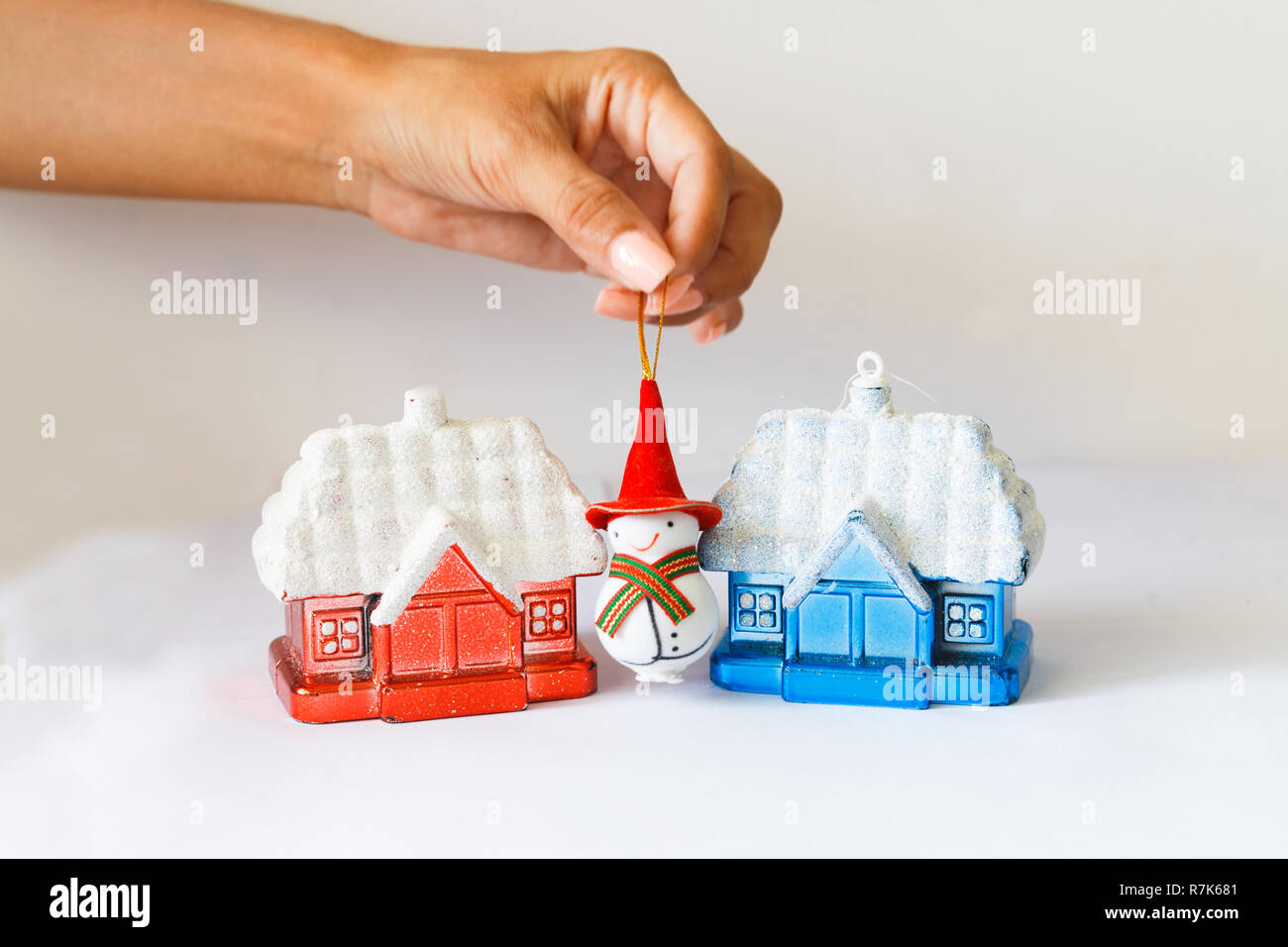 New Year's toys. a snowman in a big red cap stands between the red and ...
