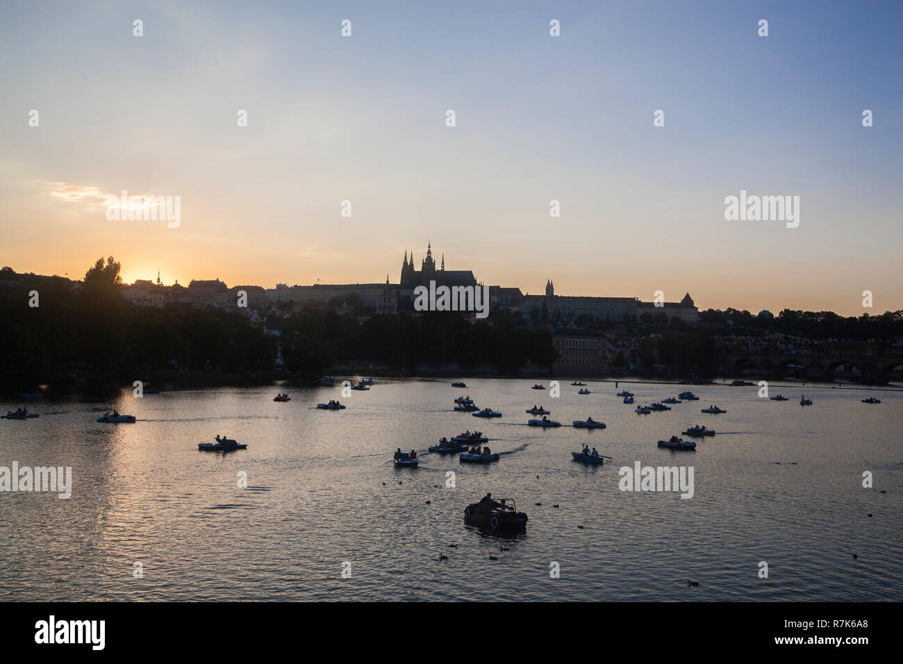 Prague Castle and boats on river Vltava at sunset Stock Photo - Alamy