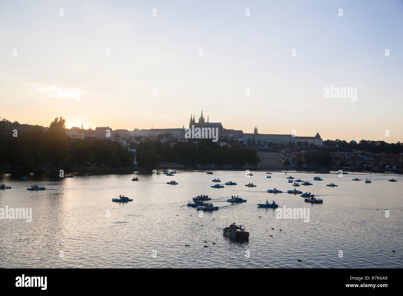 Prague Castle and boats on river Vltava at sunset Stock Photo - Alamy