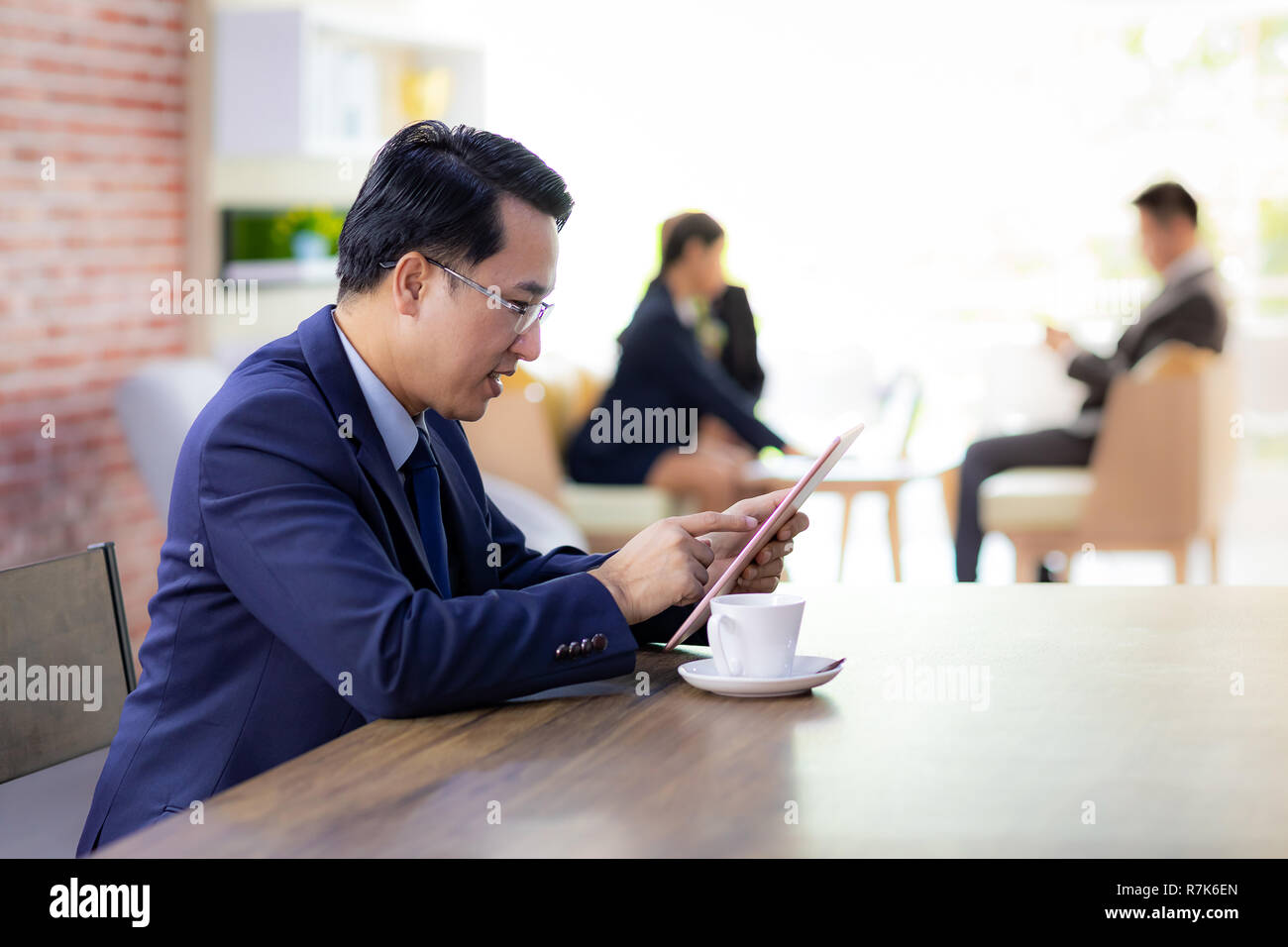 Portrait of Businessman working in cafe using smart phone tablet with ...